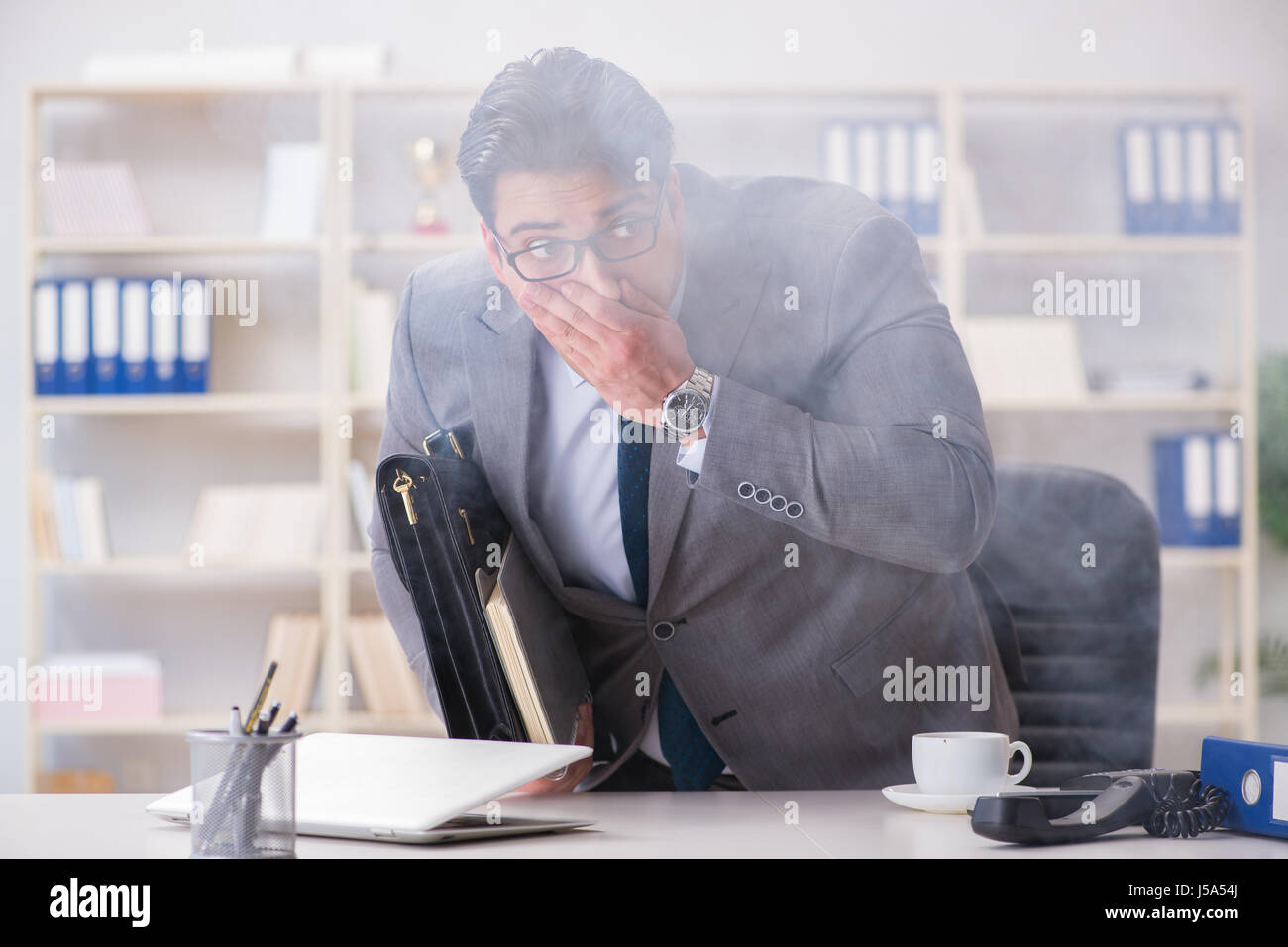Businessman during fire alarm in office Stock Photo - Alamy