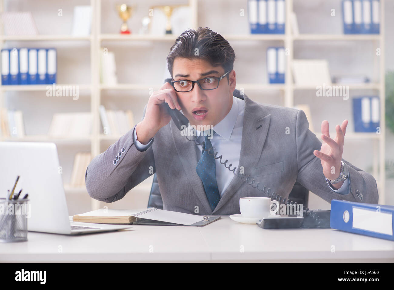 Businessman during fire alarm in office Stock Photo - Alamy
