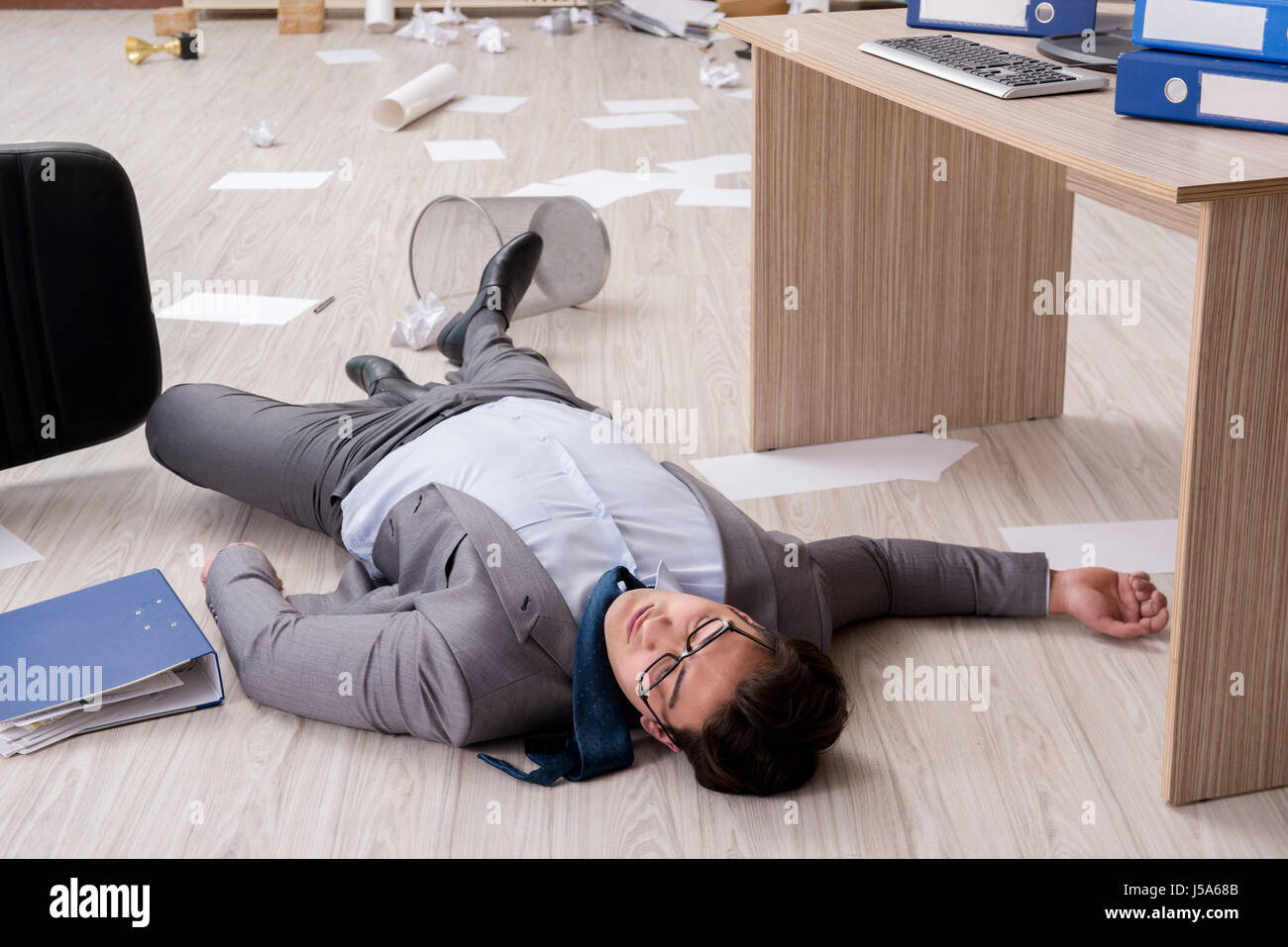 Businessman dead on the office floor Stock Photo - Alamy