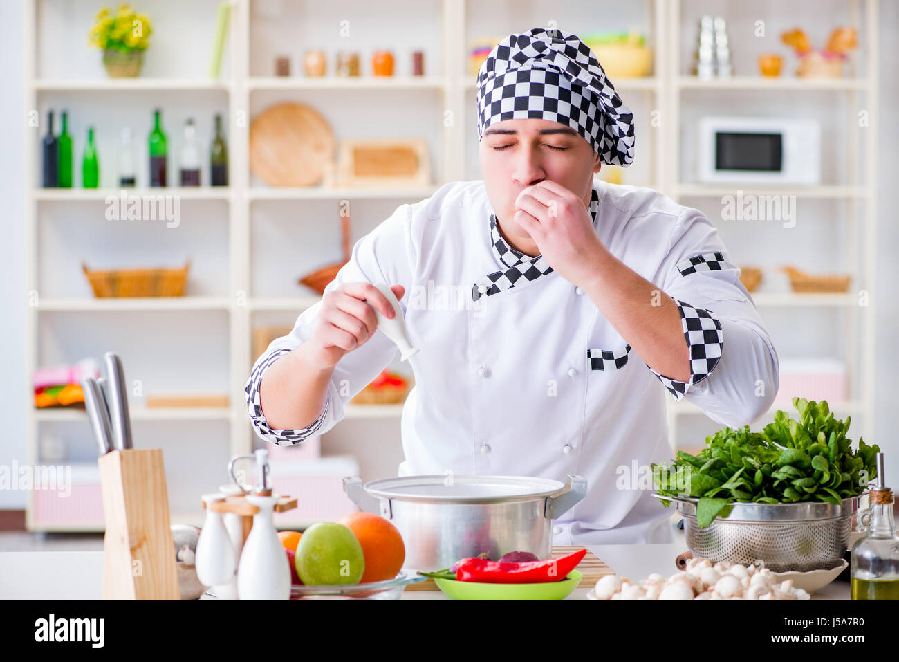 Young male cook working in the kitchen Stock Photo - Alamy