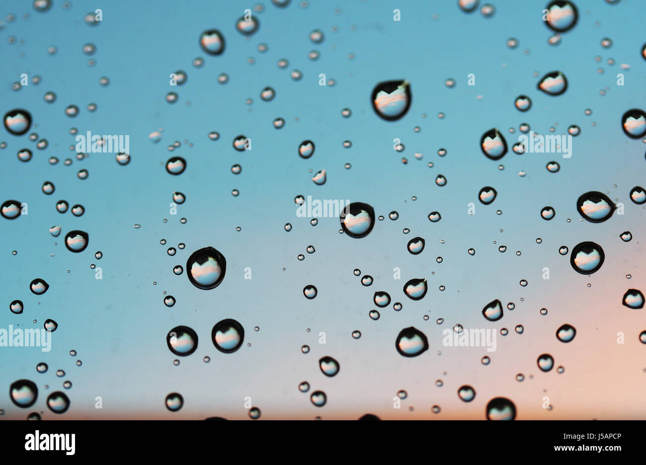 blue window porthole dormer window pane raindrop reflection mirroring orange Stock Photo - Alamy
