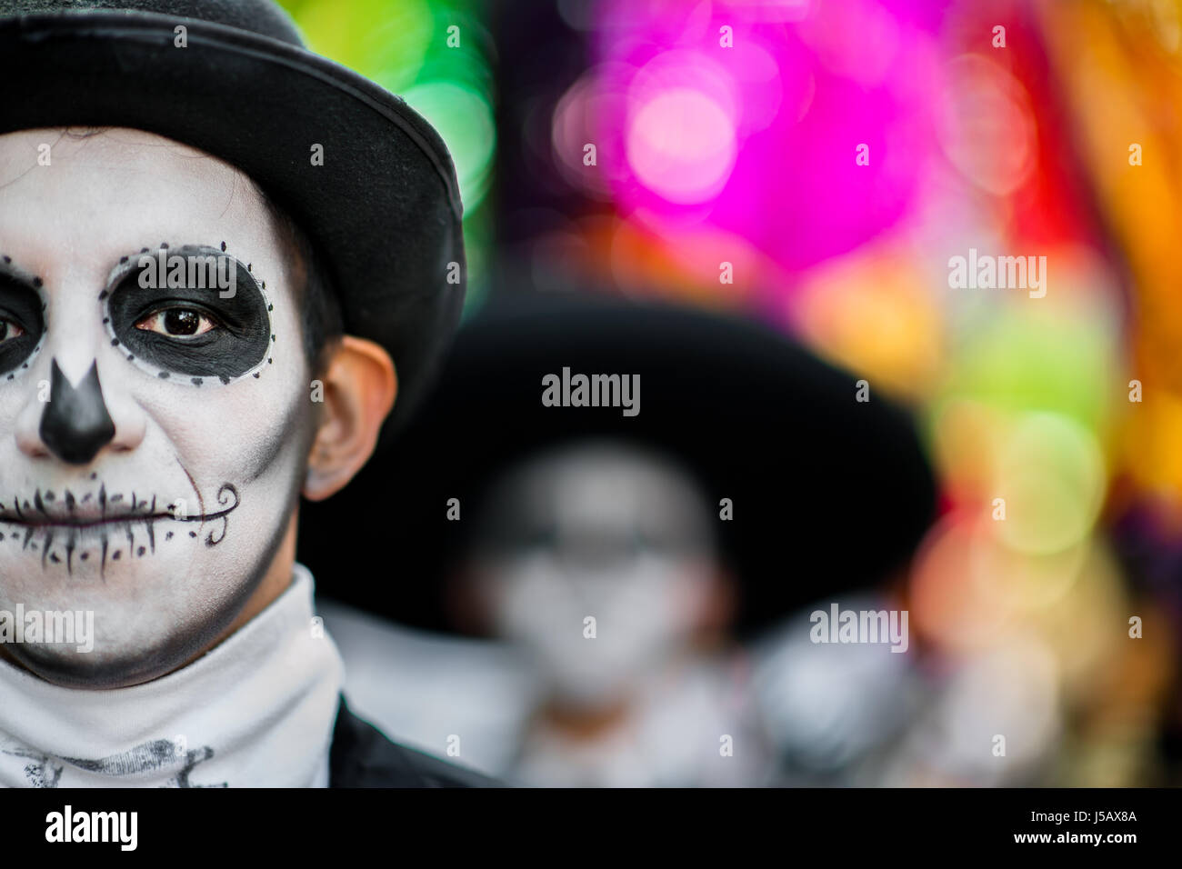 A young man, dressed as La Catrina, walks through the town during the ...