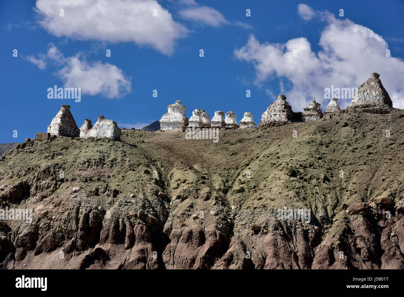 White Buddhist Tibetan ancient stupa on the crest of high mountain ...