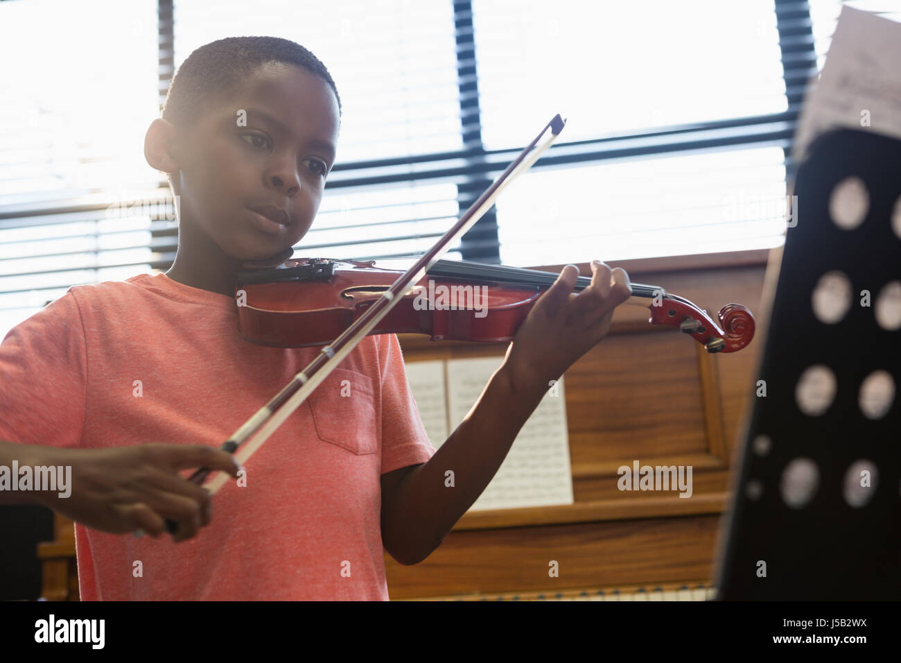 Boy playing violin while sitting in classroom at school Stock Photo - Alamy
