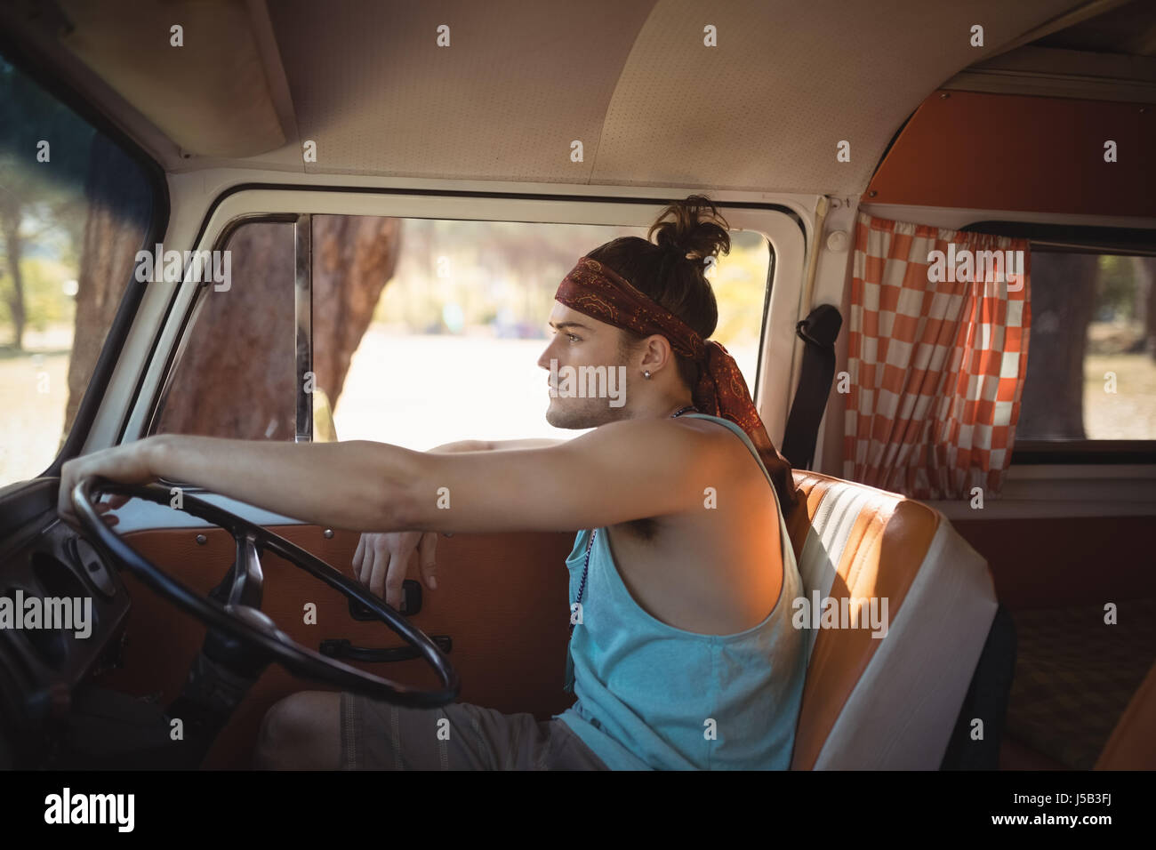 Side view of young man driving mini van Stock Photo - Alamy