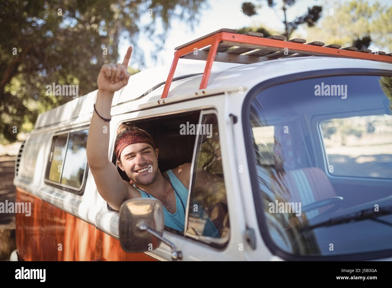Portrait of smiling man pointing while driving van Stock Photo - Alamy