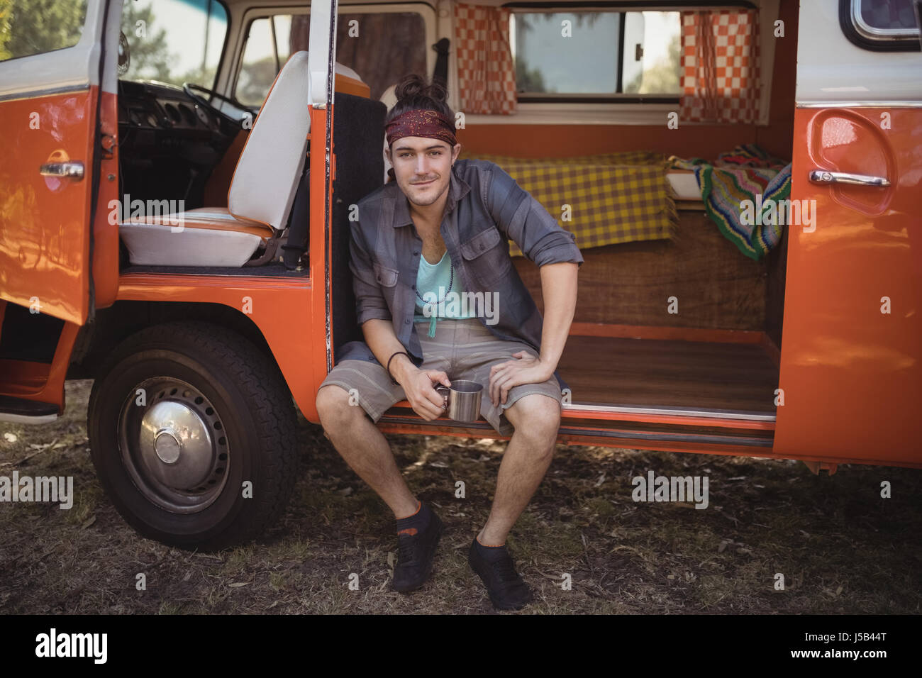 Full length of yuong man sitting in mini van Stock Photo - Alamy