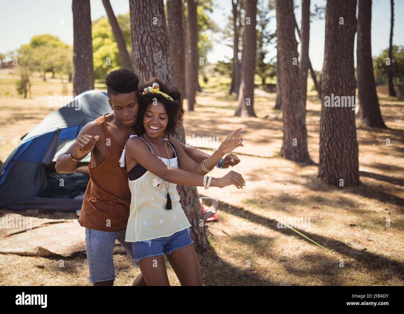 Happy couple dancing on field while camping at forest Stock Photo - Alamy
