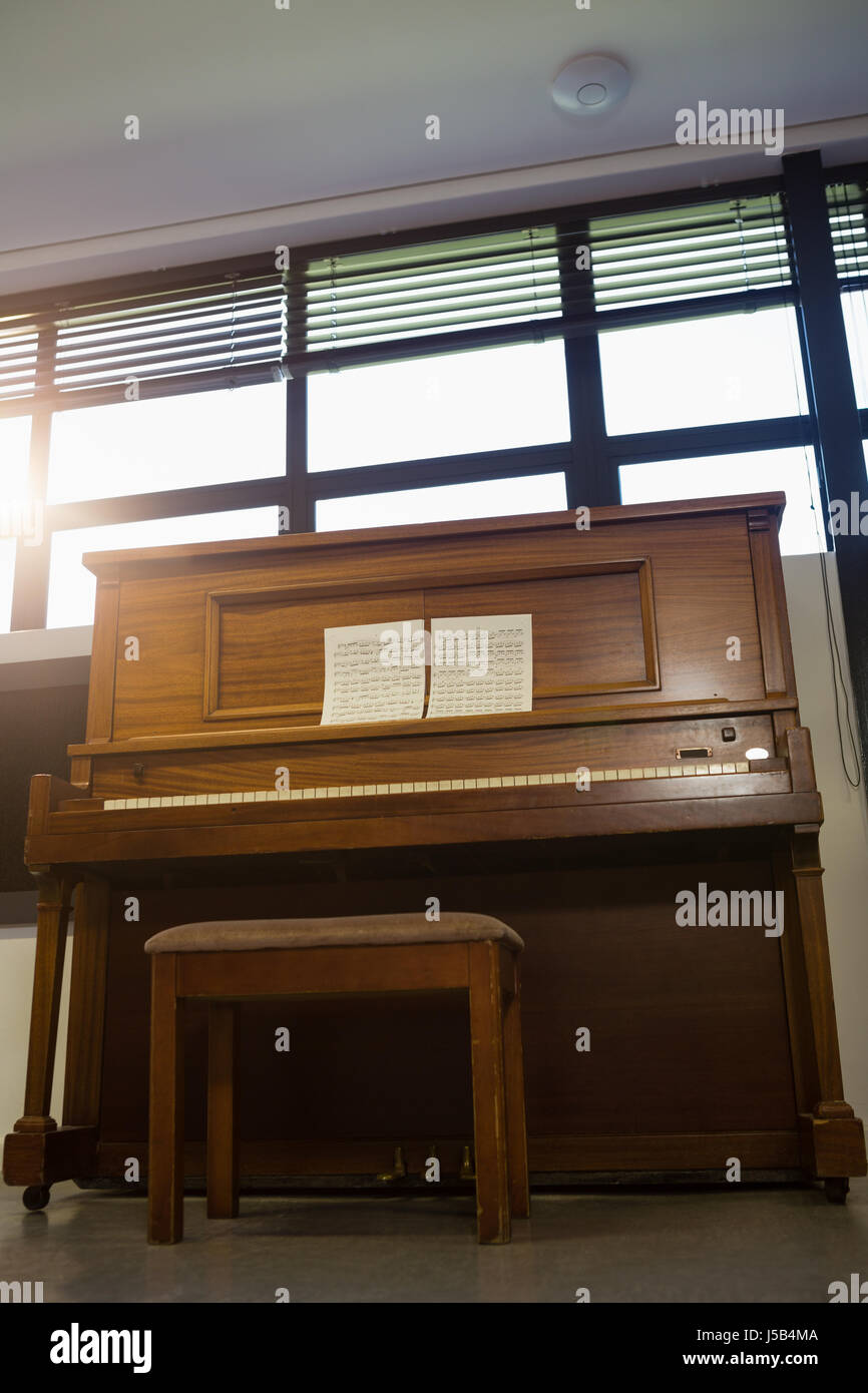 Low angle view of piano against window at home Stock Photo - Alamy