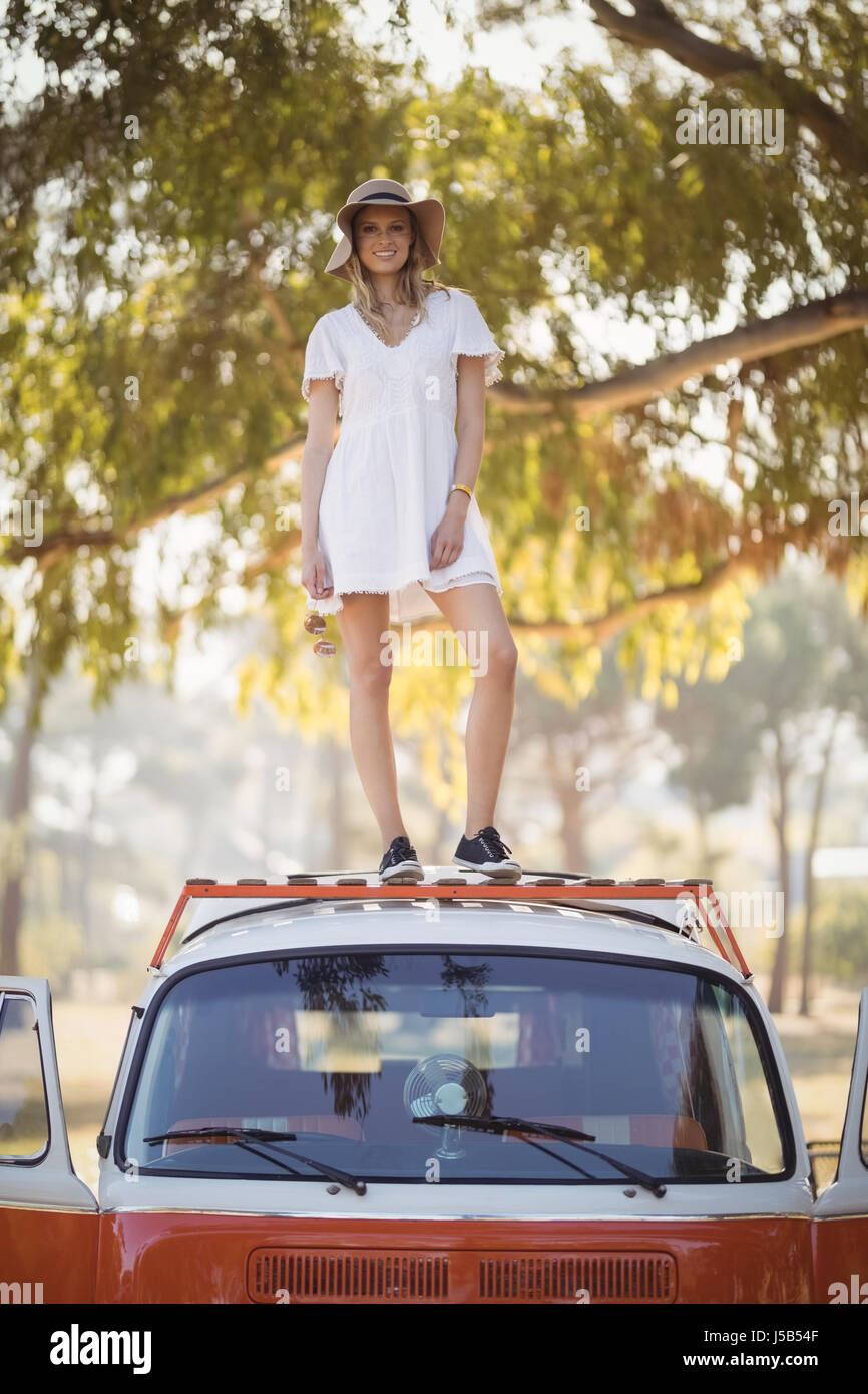 Full length of woman standing on van against tree Stock Photo - Alamy