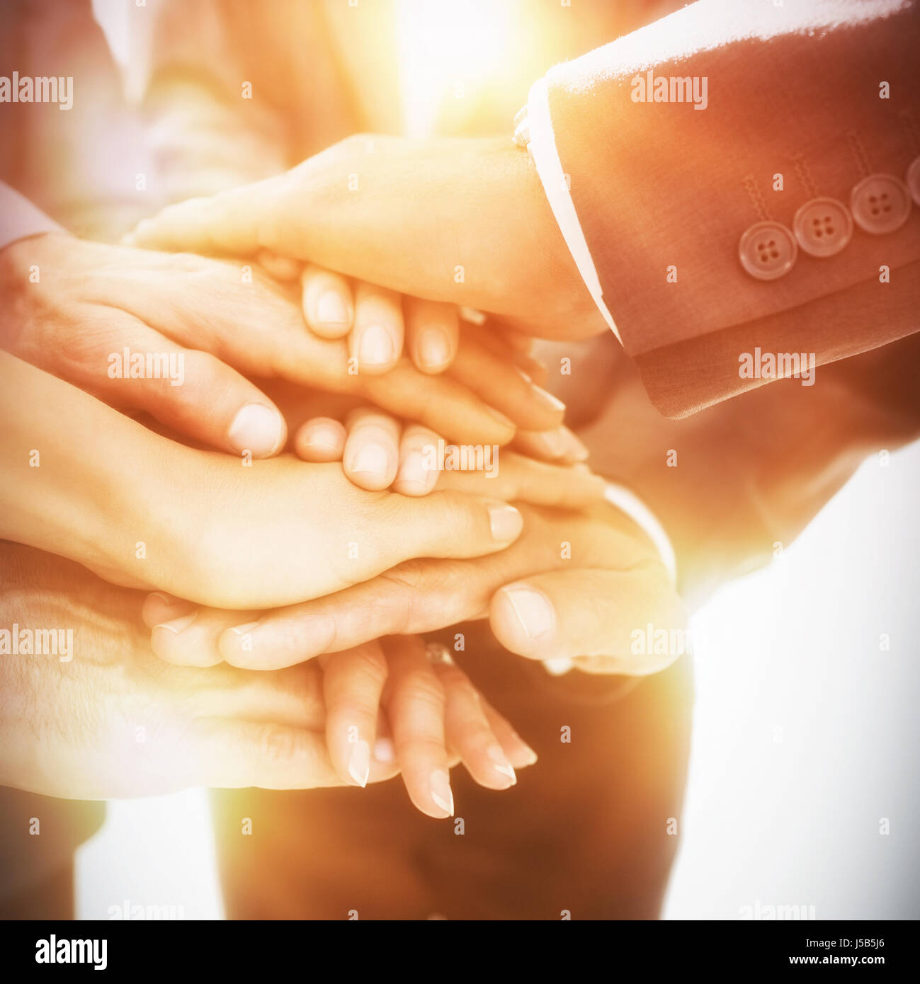 Business team stacking hands together in office Stock Photo - Alamy