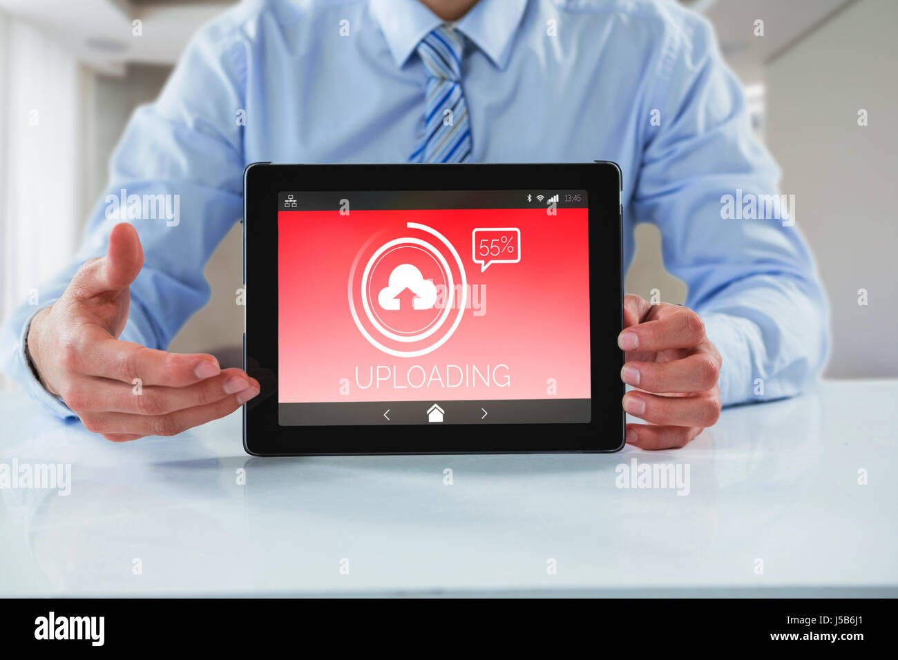 Businessman showing digital tablet against uploading text with icon ...