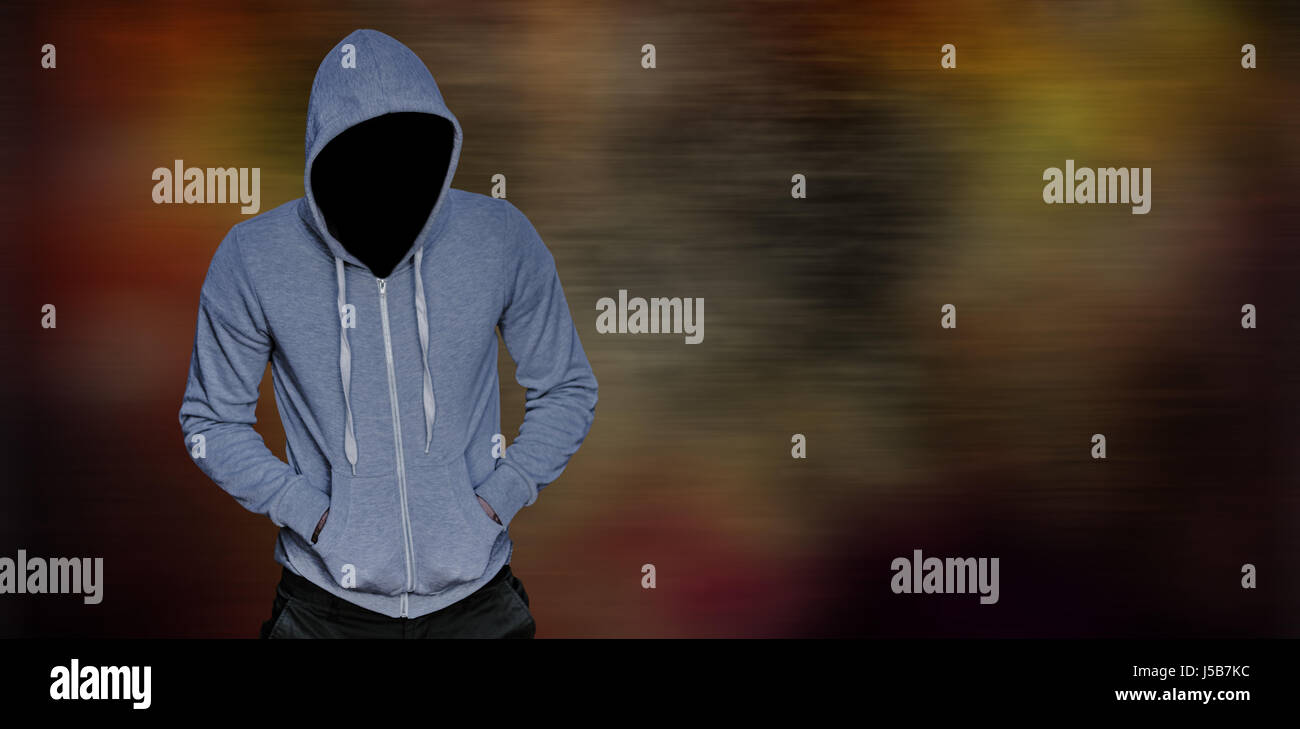 Robber in gray hoodie with hands in pockets against dark background ...