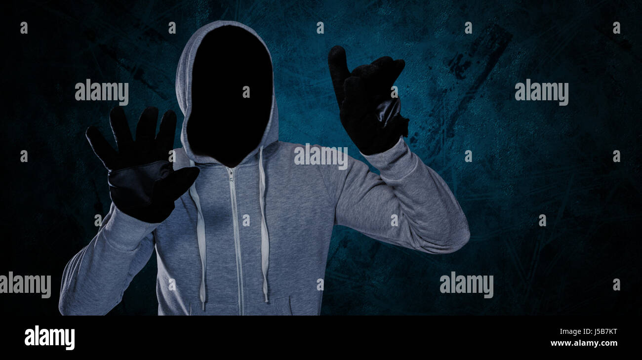 Robber with hood and gloves against dark background Stock Photo - Alamy