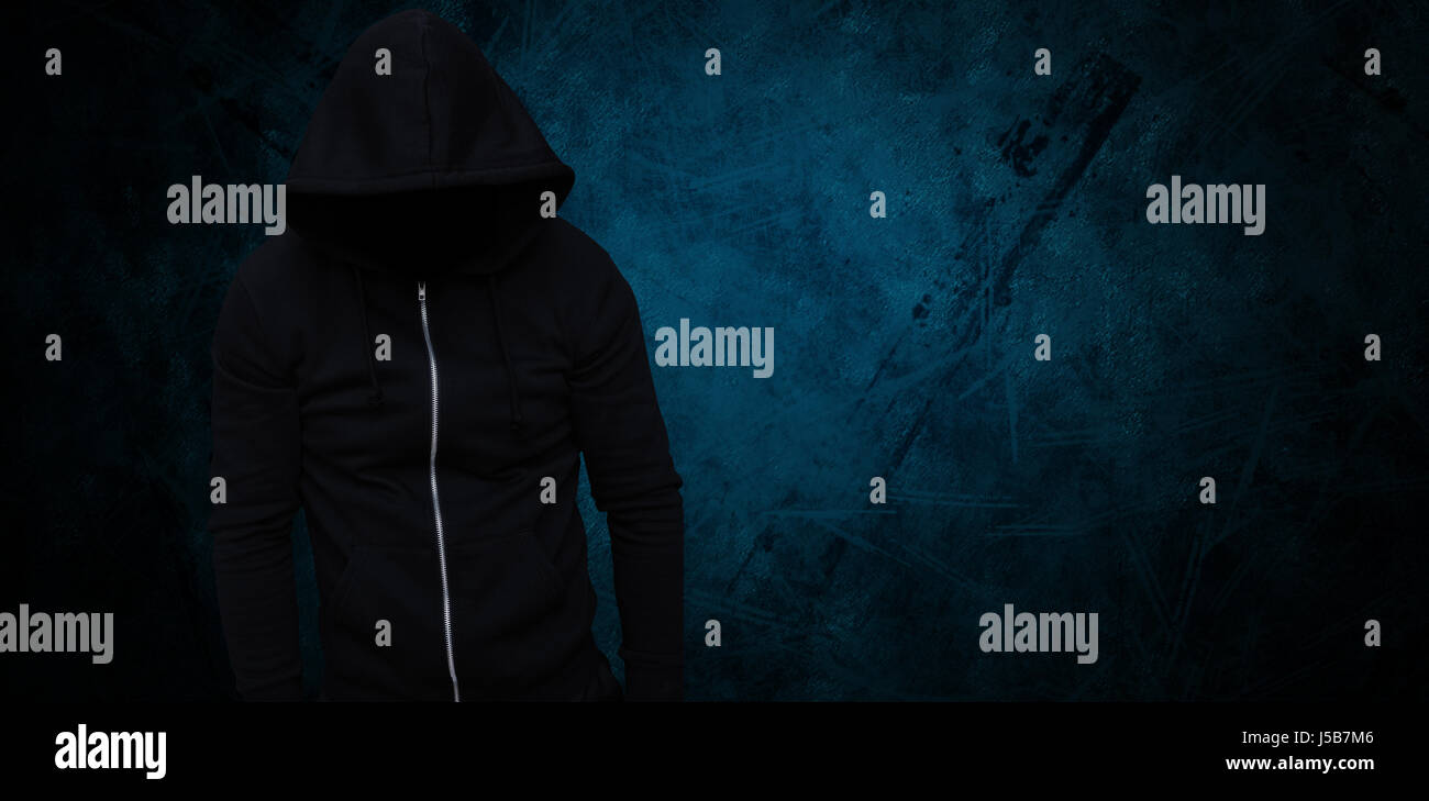 Robber wearing black hoodie against dark background Stock Photo - Alamy