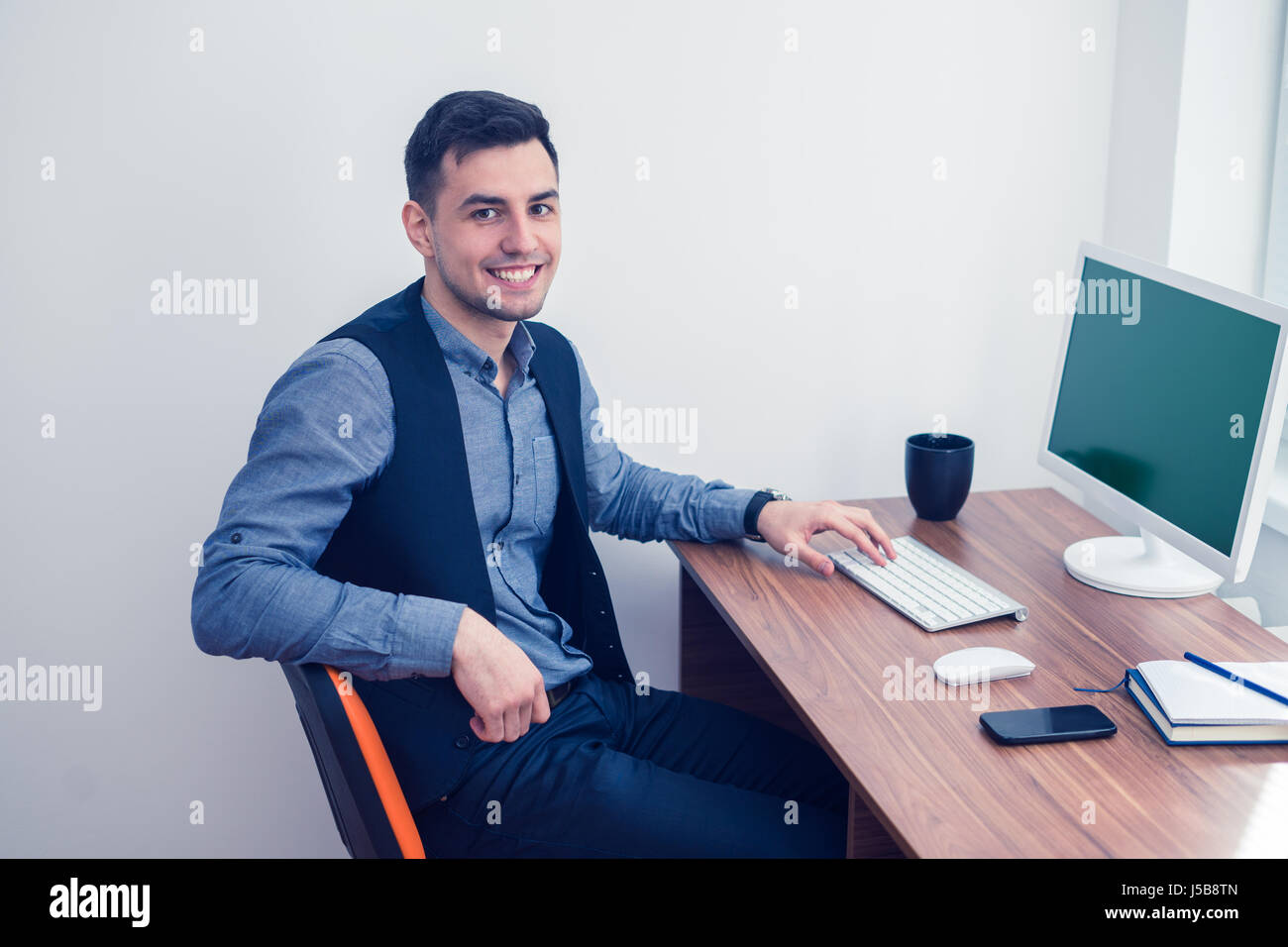 Happy office worker smiling and looking at the camera Stock Photo - Alamy