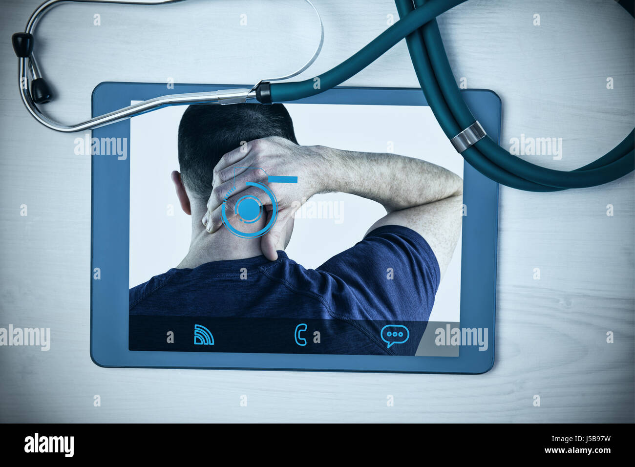 Rear view of a man with neck pain against tablet and stethoscope on ...