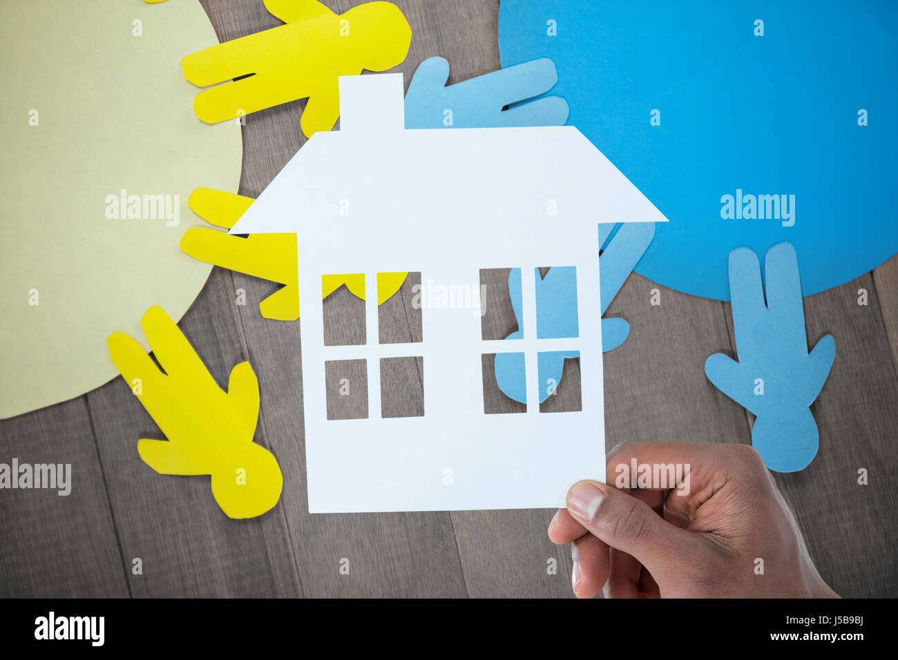 High angle view of blue and yellow paper cut out figures on wooden ...