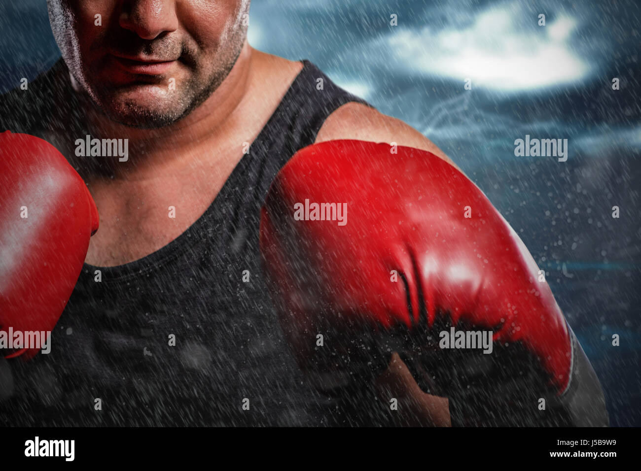 Boxer performing boxing stance against road against overcast sky with ...