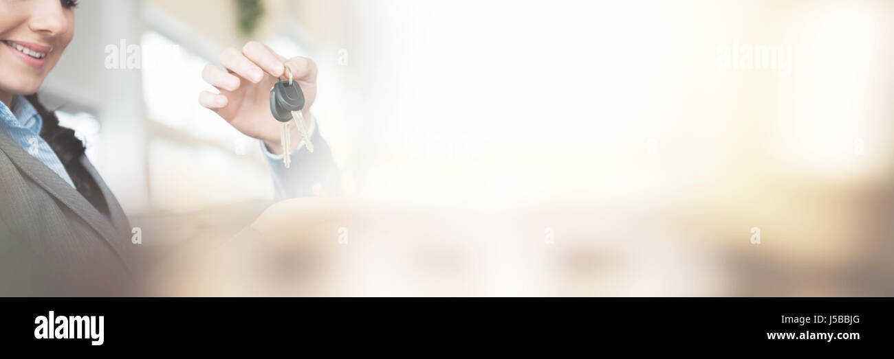 Smiling woman receiving keys from man at shop Stock Photo - Alamy