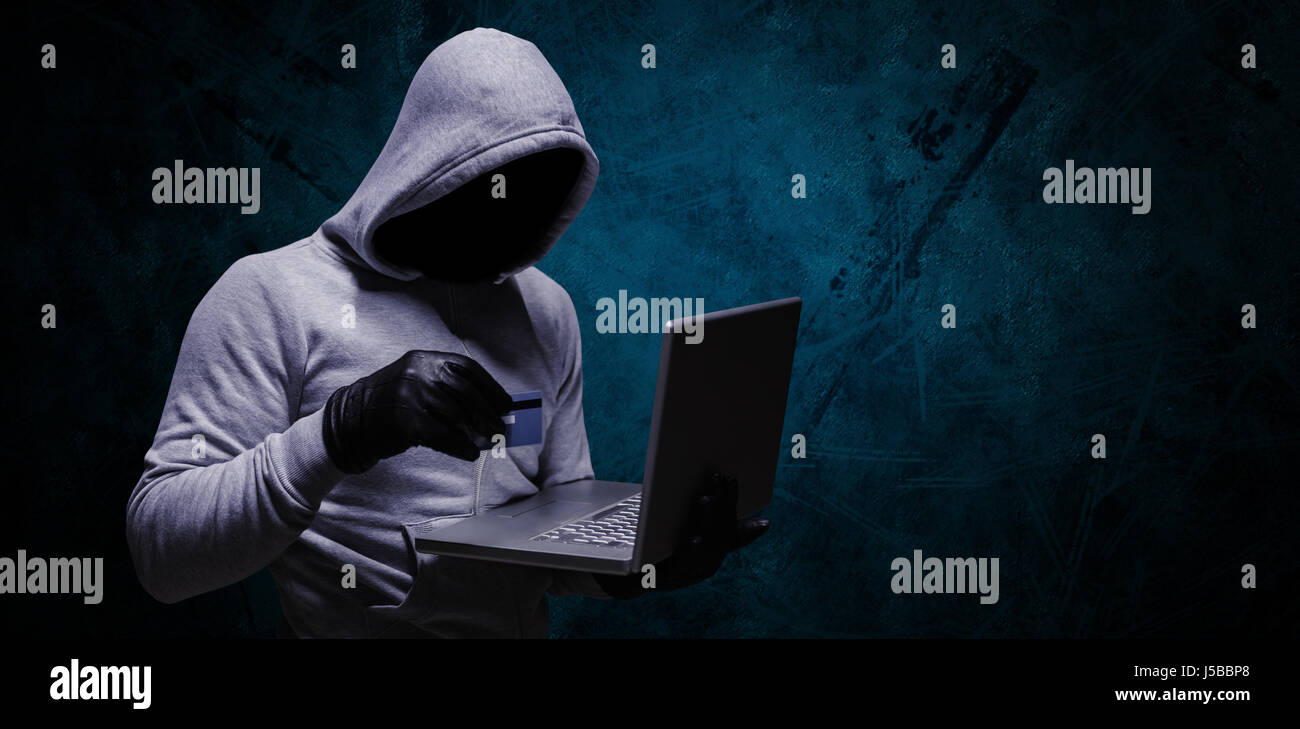 Hacker using credit card for cyber crime against dark background Stock ...