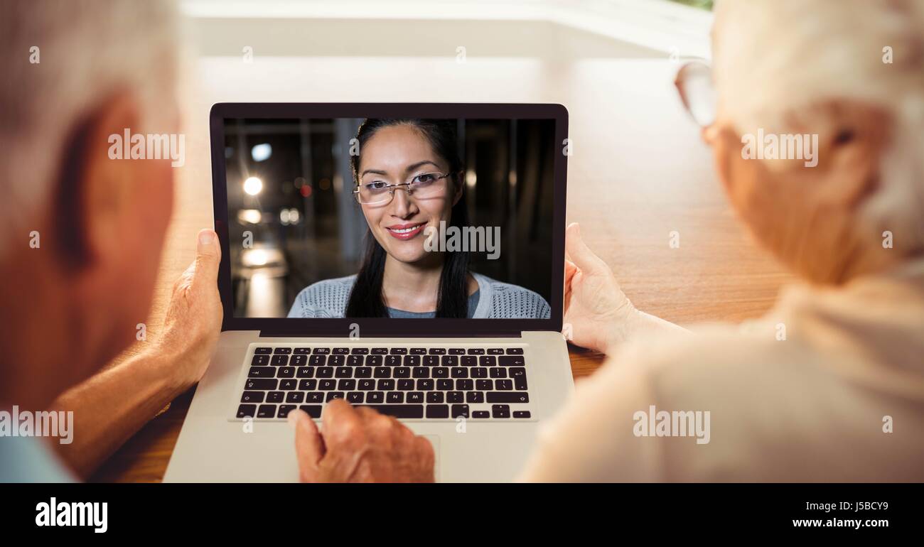 Digital composite of Rear view of senior couple having video conference ...