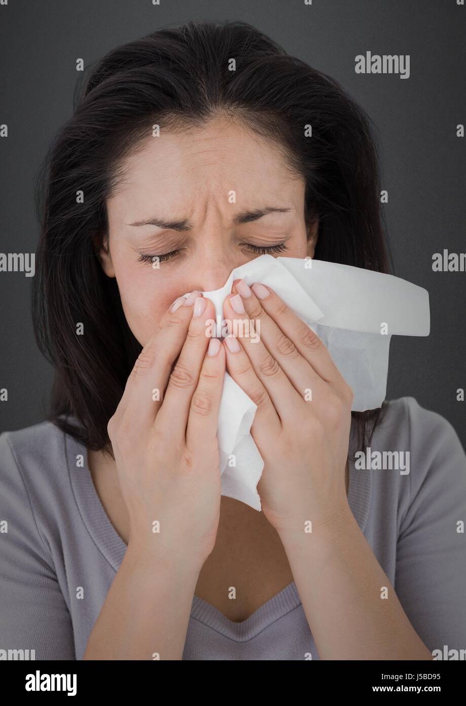 Digital composite of Woman crying into tissue against grey wall Stock ...