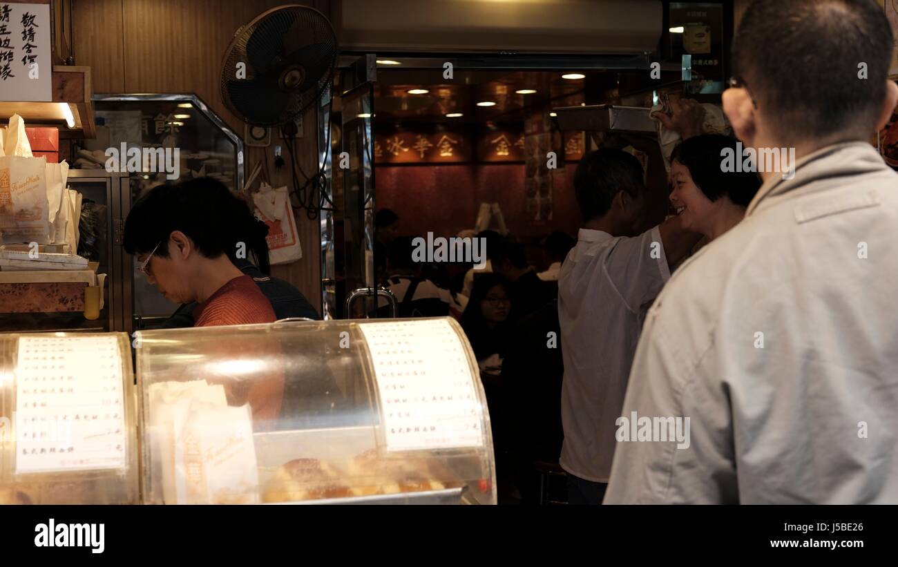 People waiting in line to go into shop and Vendor Selling buns and egg ...