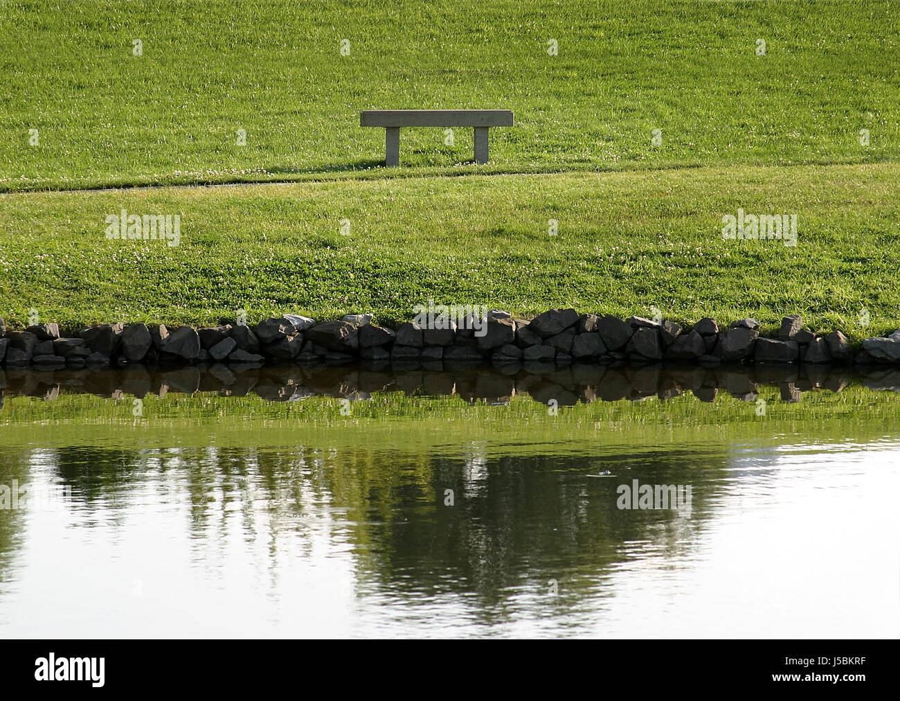 bank on lawn in front of lake Stock Photo - Alamy