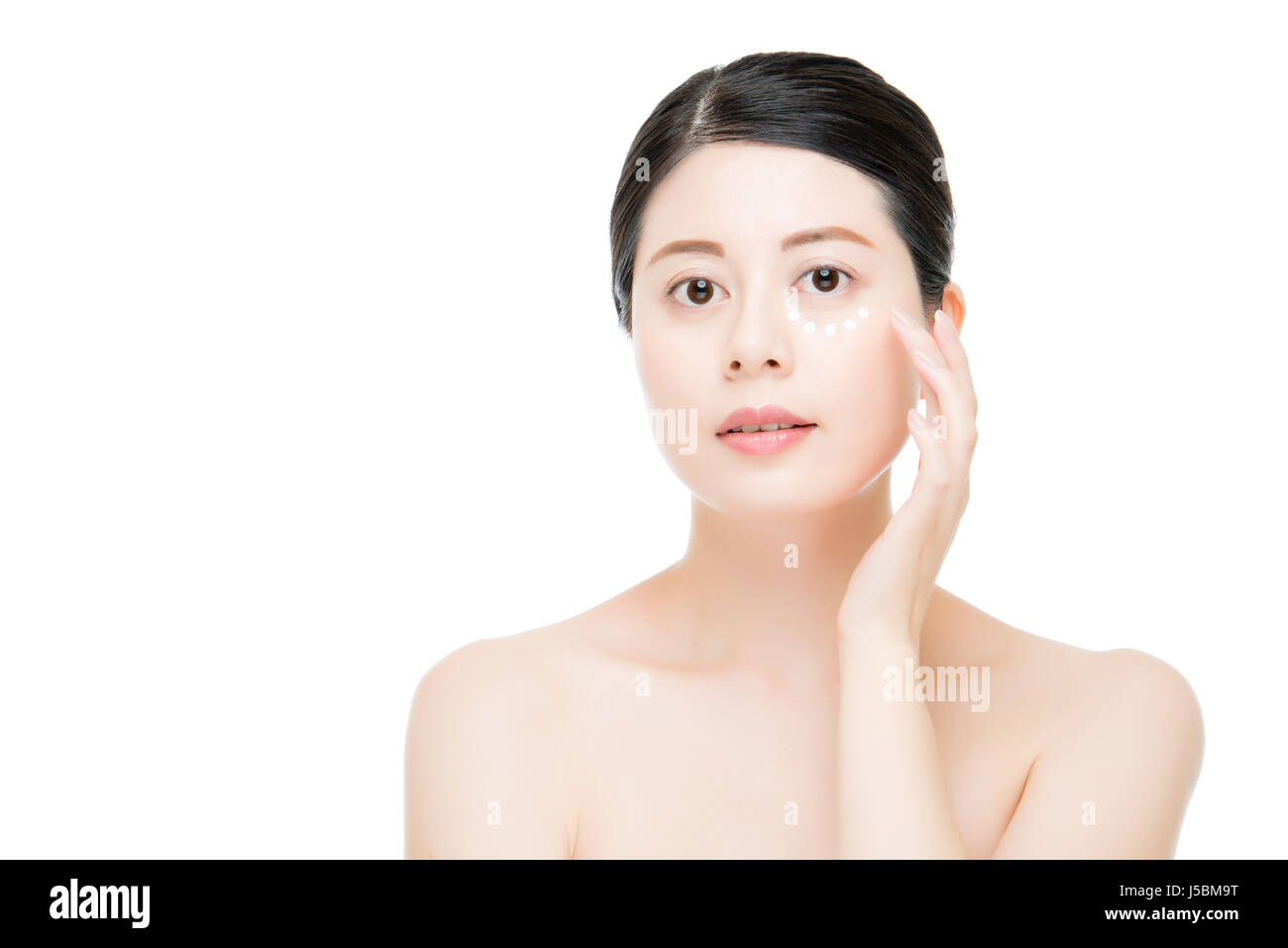 Young And Beautiful Happy Woman Applying Moisturizing Cream On Her Face