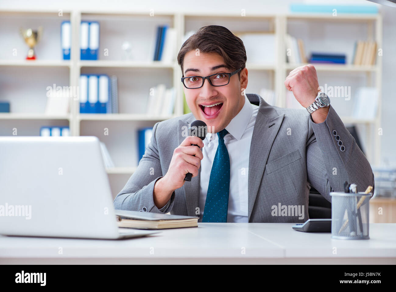 Businessman singing in the office Stock Photo - Alamy