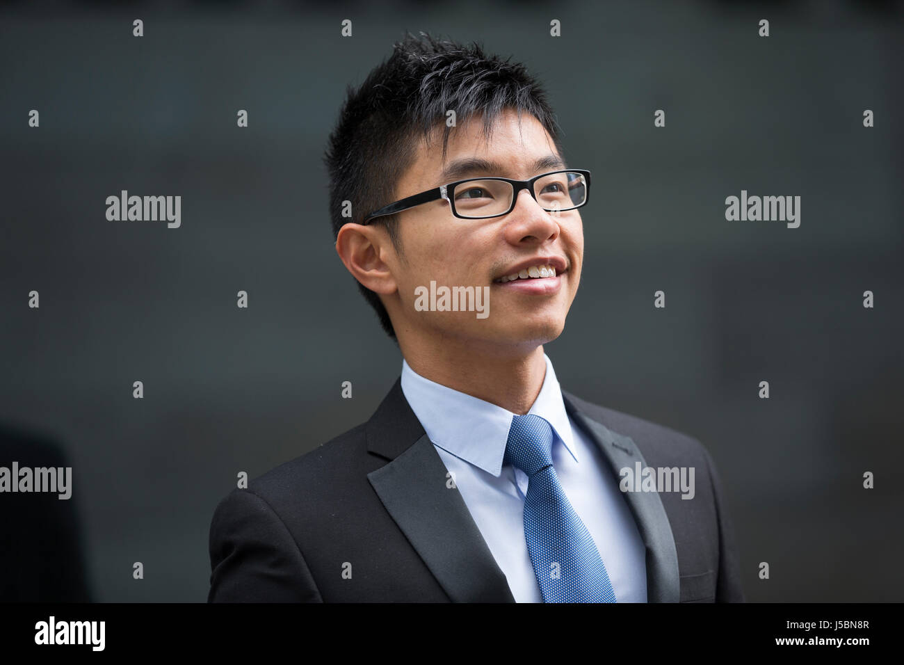 Portrait of a Chinese businessman outside modern office building ...
