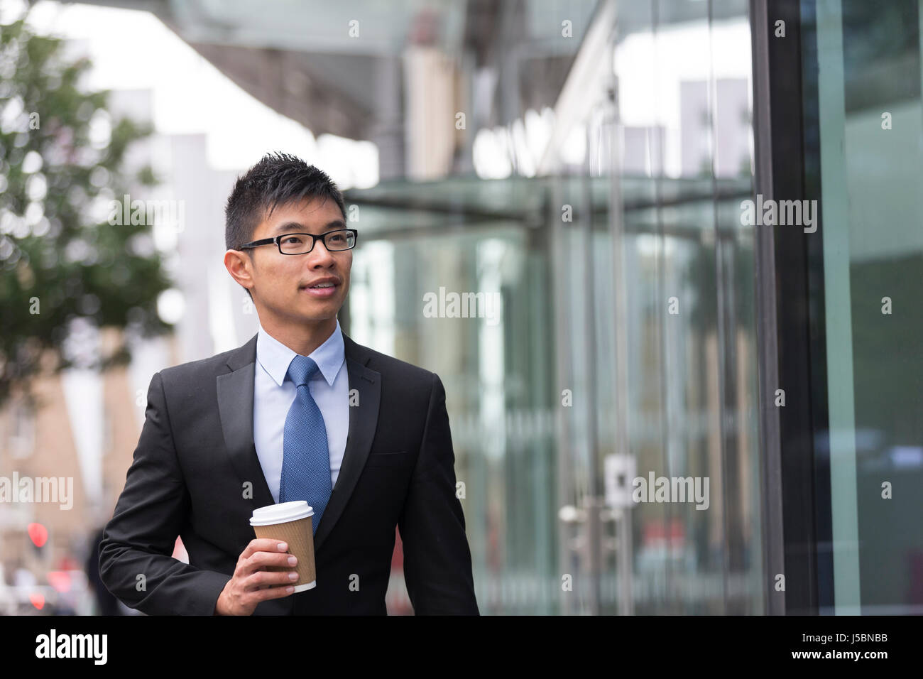 Portrait of a Chinese businessman outside modern office building ...