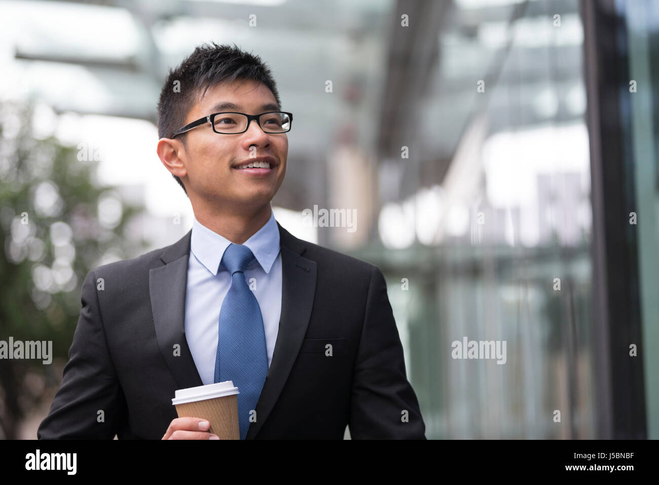 Portrait of a Chinese businessman outside modern office building ...