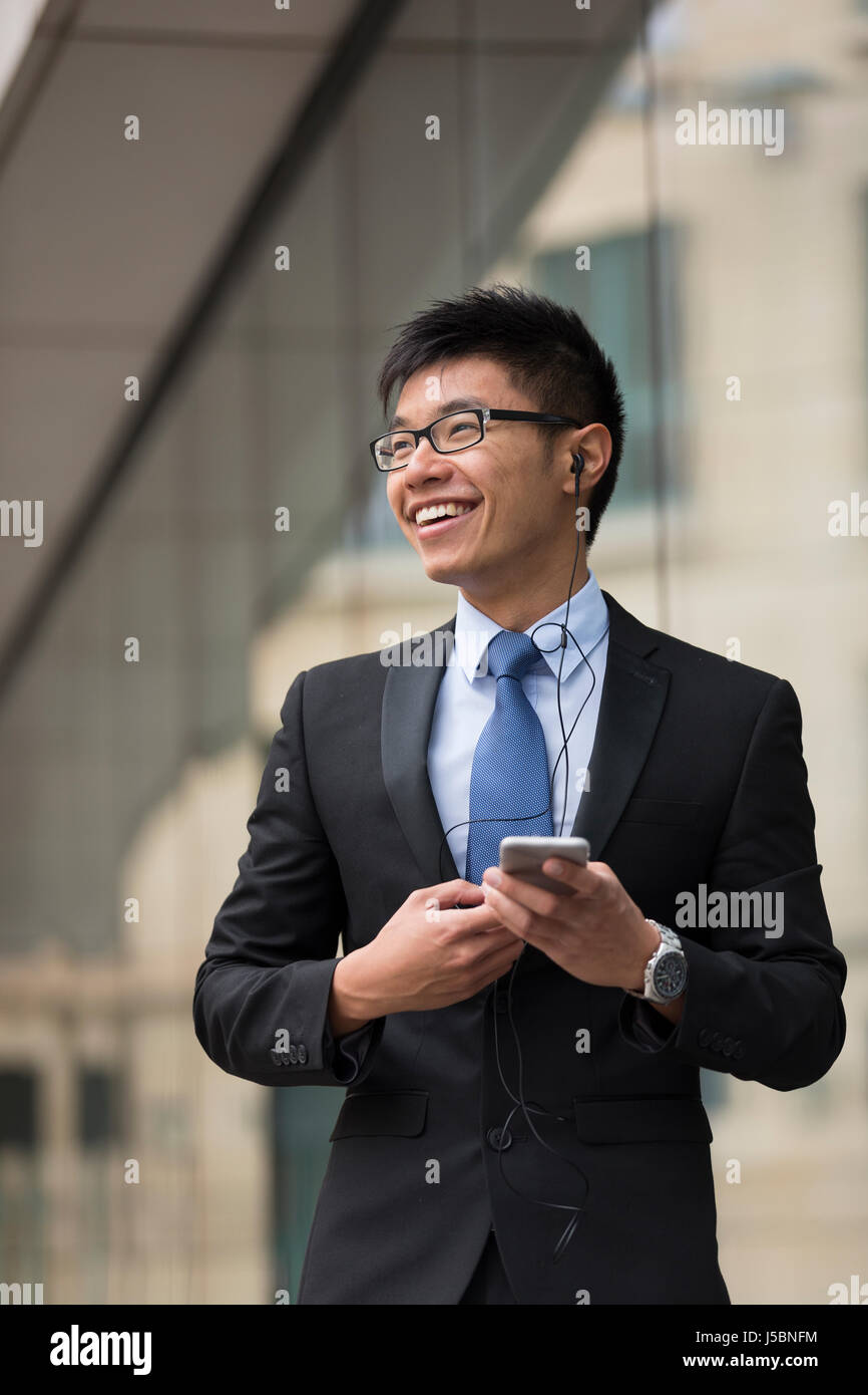 Chinese business Man using his Smart phone with handsfree kit Stock ...