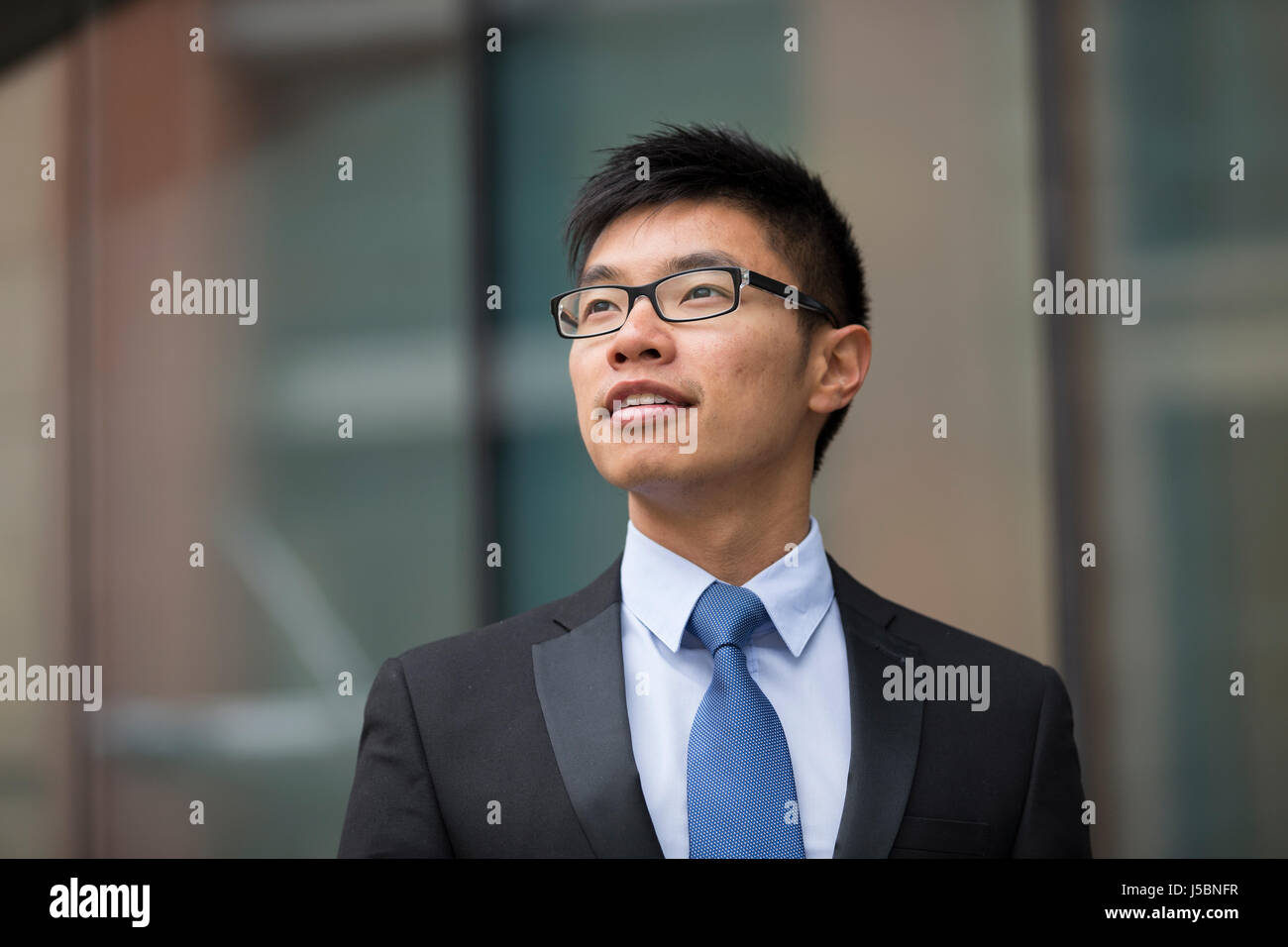 Portrait of a Chinese businessman outside modern office building ...