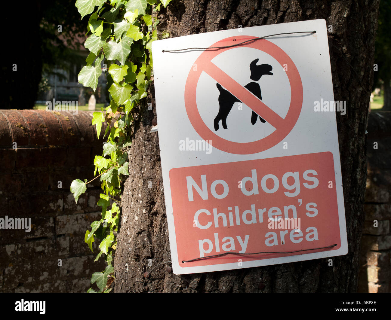 No dogs childrens play area warning sign mounted on tree trunk Stock ...