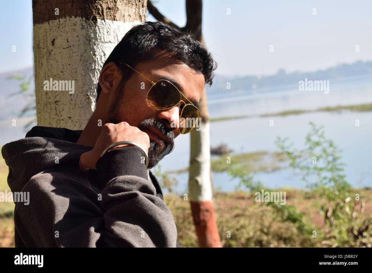 Young man standing near a beautiful lake, Pune, Maharashtra Stock Photo ...