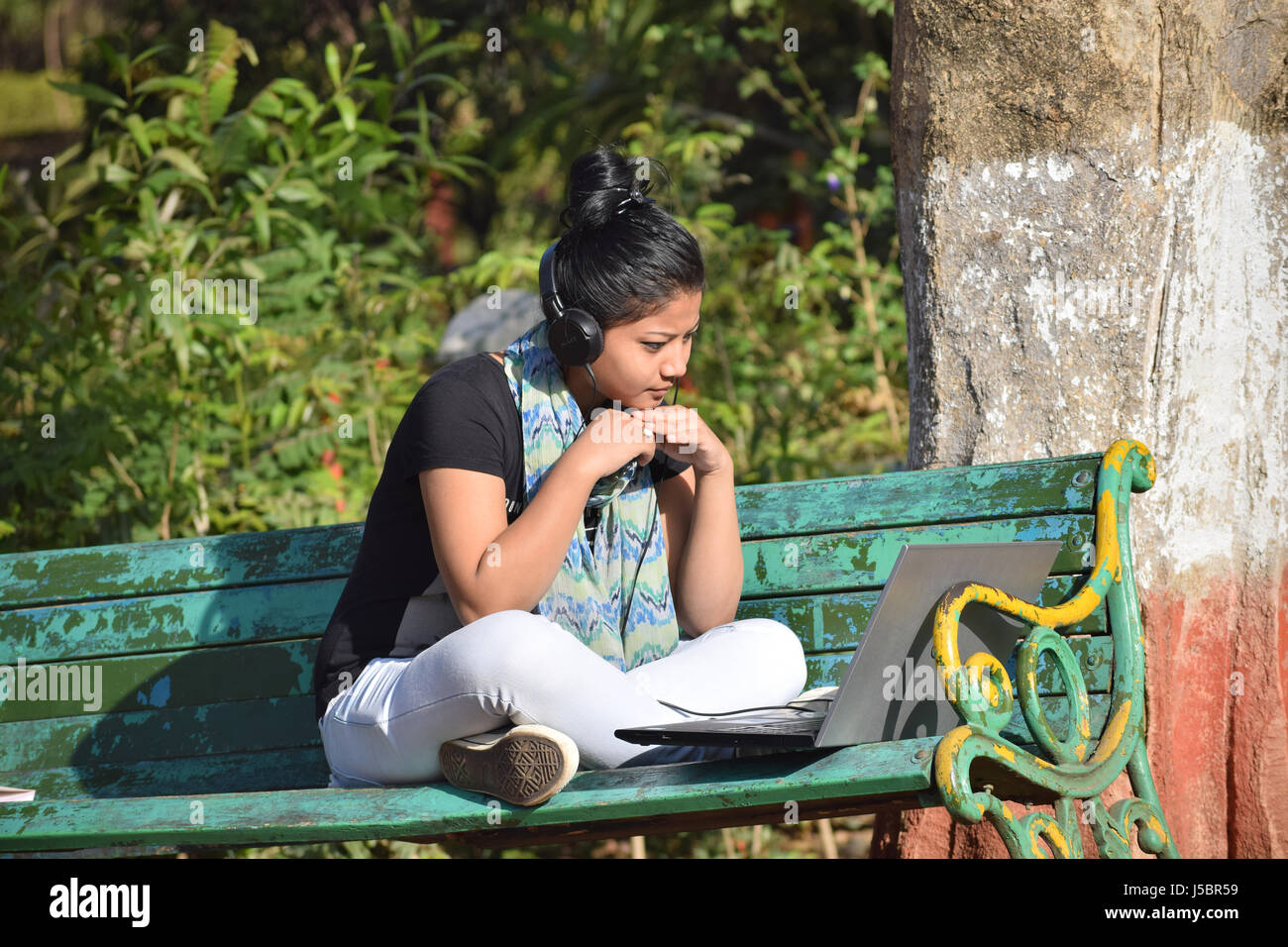 Young girl student studying outside in the garden with laptop and ...