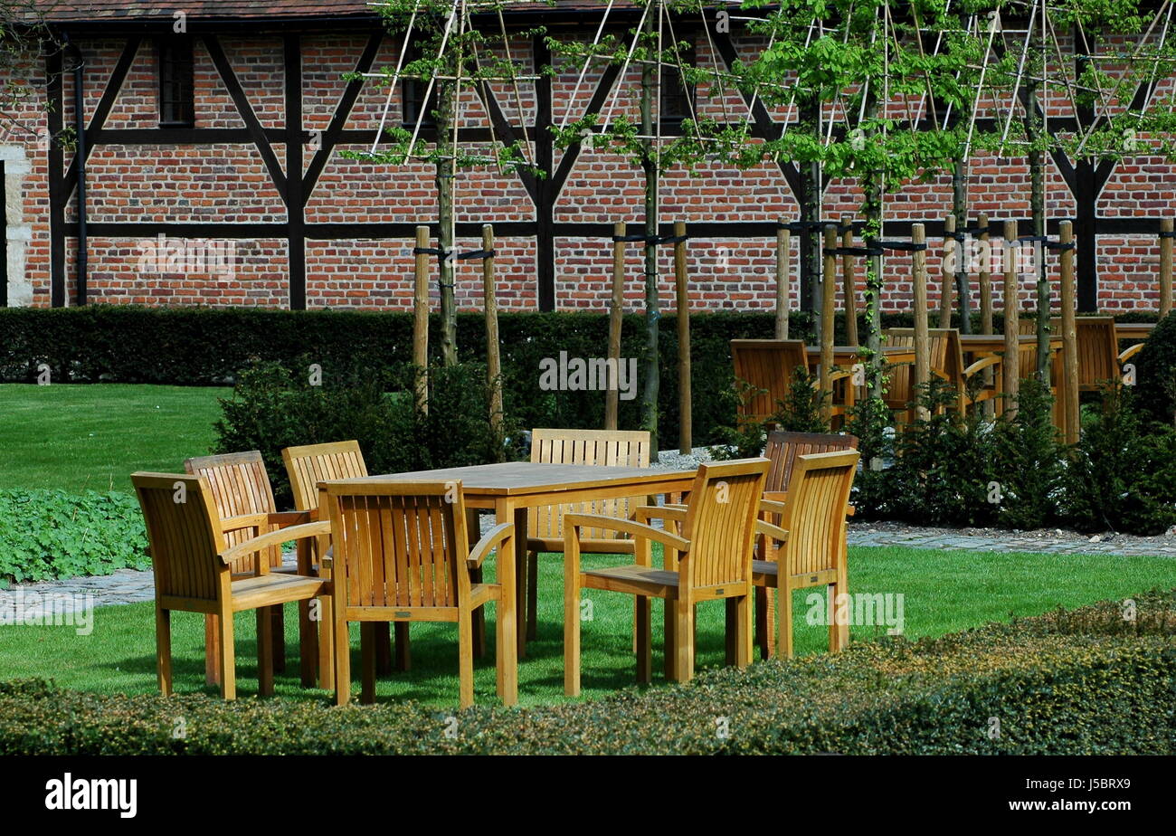 garden frame-work chairs outside linden tree house wall gardens brick ...