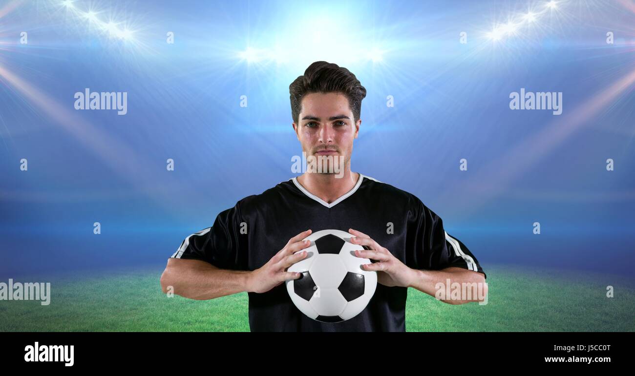 Digital composite of Confident player holding soccer ball at stadium ...