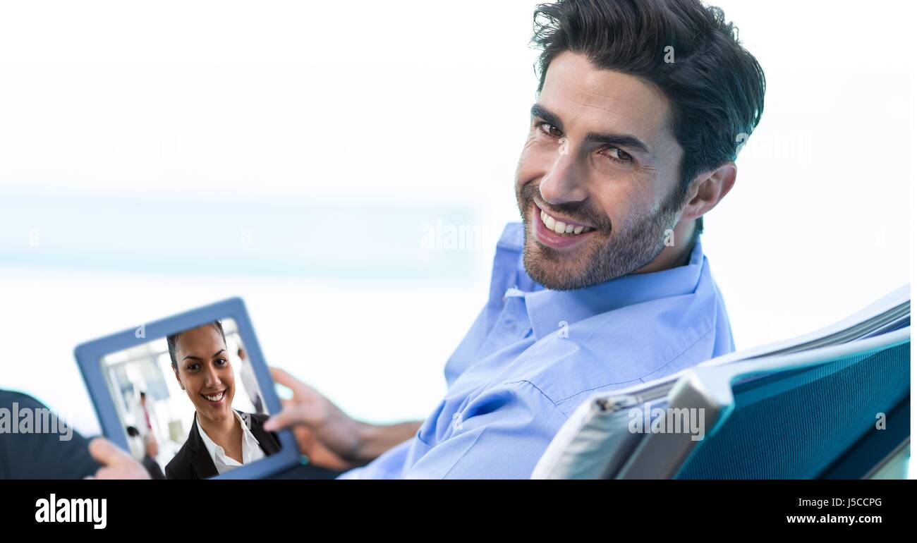 Digital composite of Smiling businessman video conferencing with ...