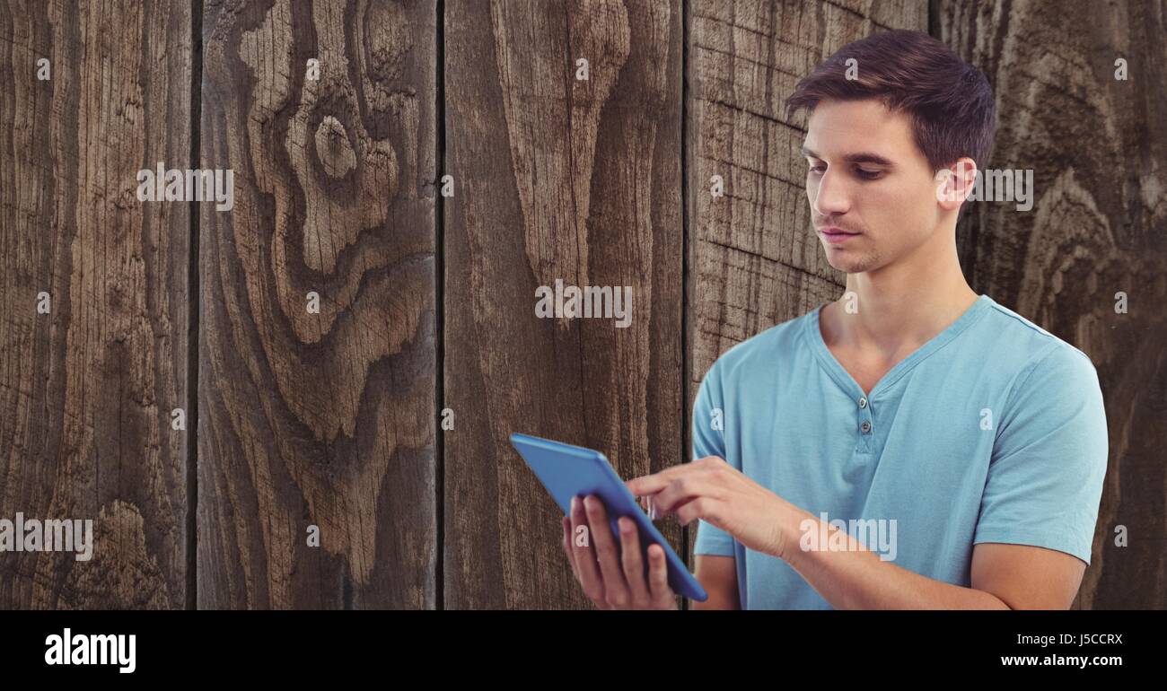 Digital composite of Young man using tablet PC against wall Stock Photo ...