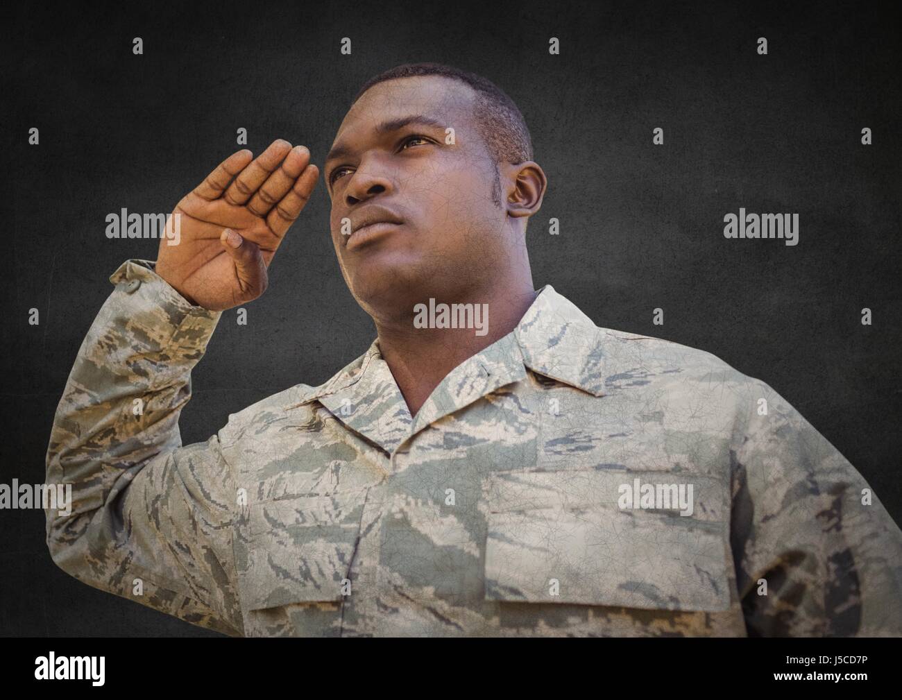 Digital composite of Soldier saluting against grey wall with grunge ...