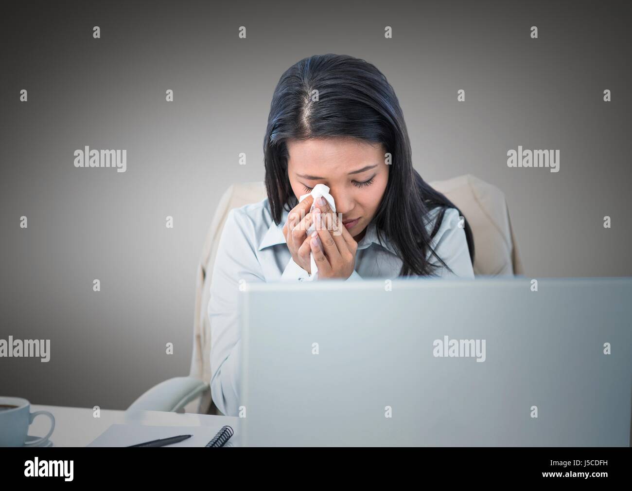 Digital composite of Woman crying at desk against grey background Stock ...