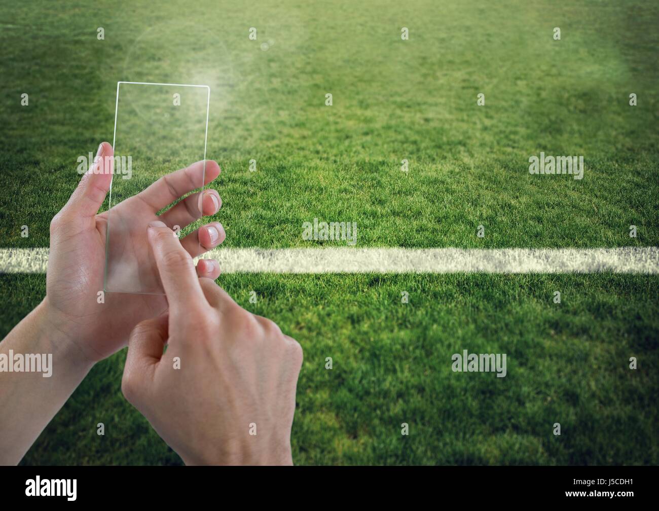 Digital composite of Hand touching glass screen on sports pitch Stock ...
