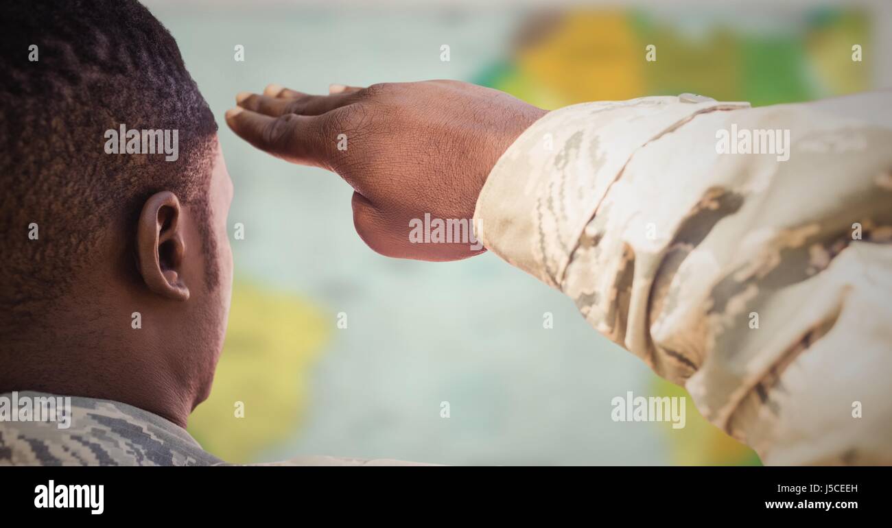 Digital composite of Back of soldier saluting against blurry map Stock ...
