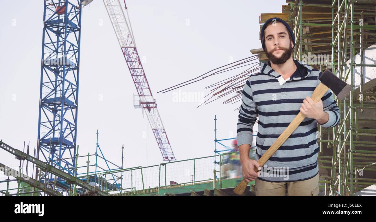 Digital composite of Hipster holding ax at construction site Stock ...