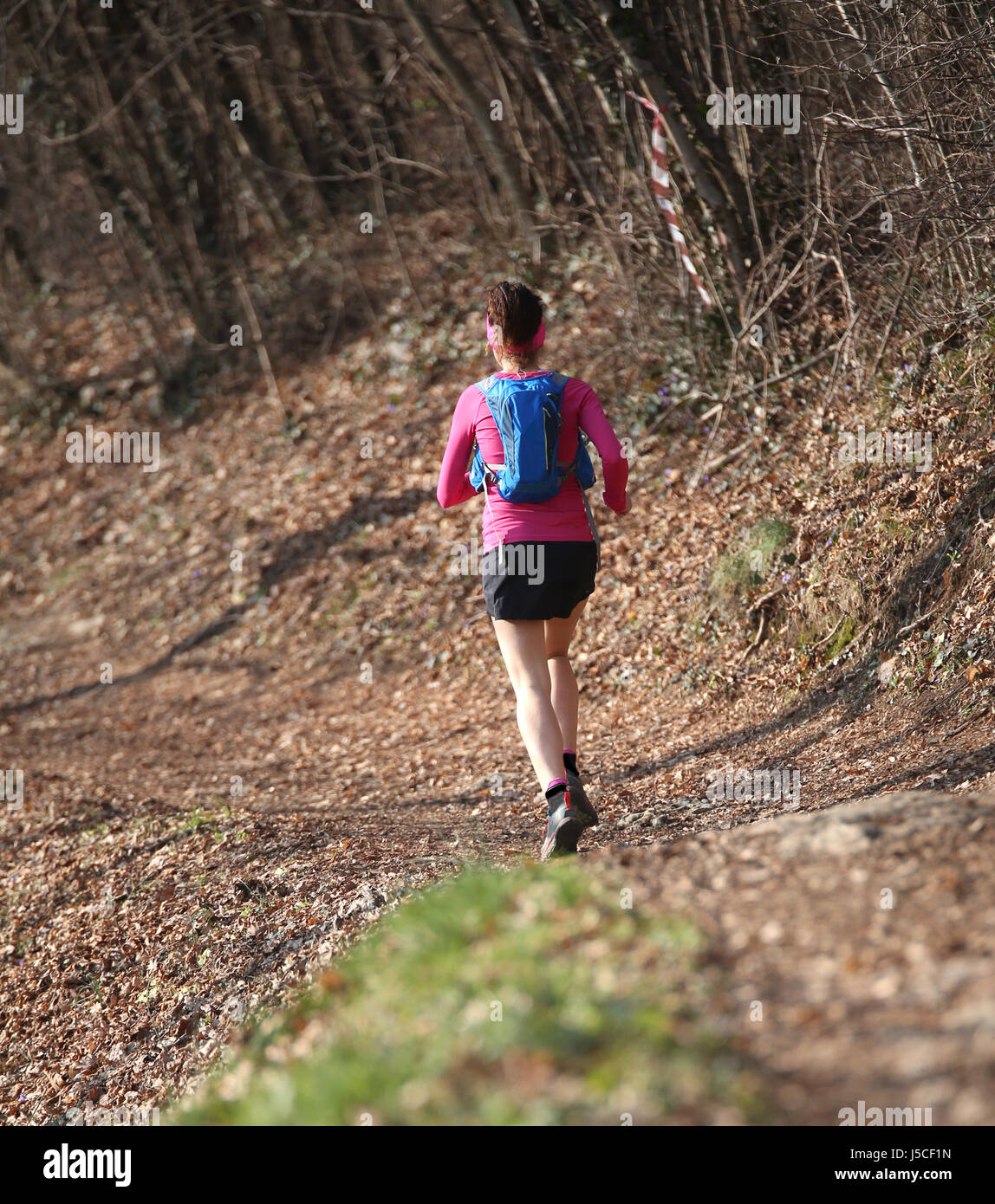 young Woman runs fast with the sport suit in the park trail ...