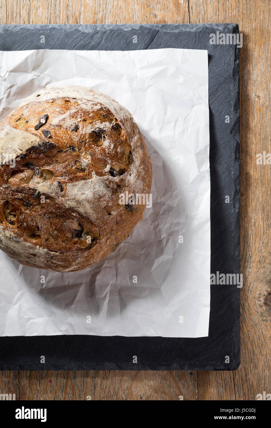Round bread loaf on Black Slate Board on a rustic wooden table Stock ...